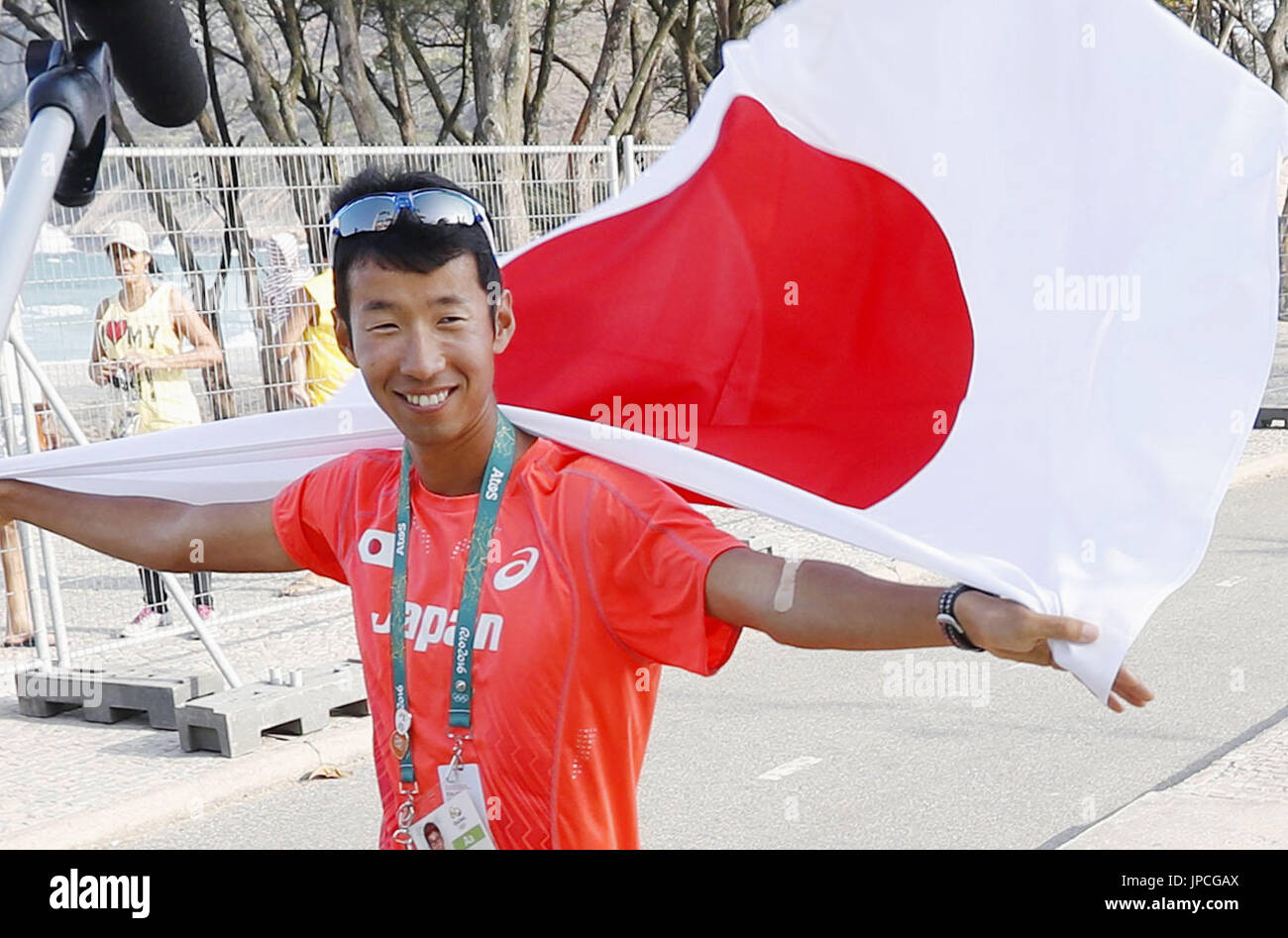 Japan's Hirooki Arai celebrates by holding the Japanese national flag ...