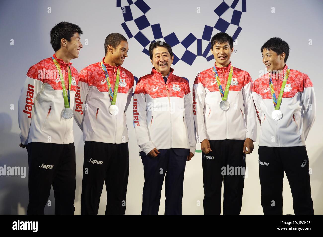 Japanese Prime Minister Shinzo Abe (C) smiles as he stands alongside ...