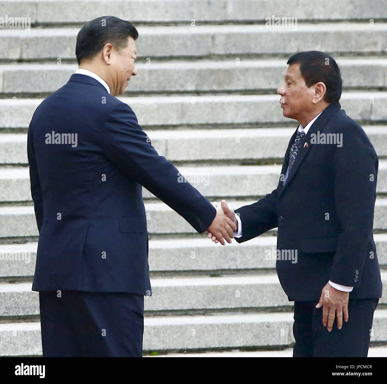 Chinese President Xi Jinping (L) shakes hands with Philippine President ...