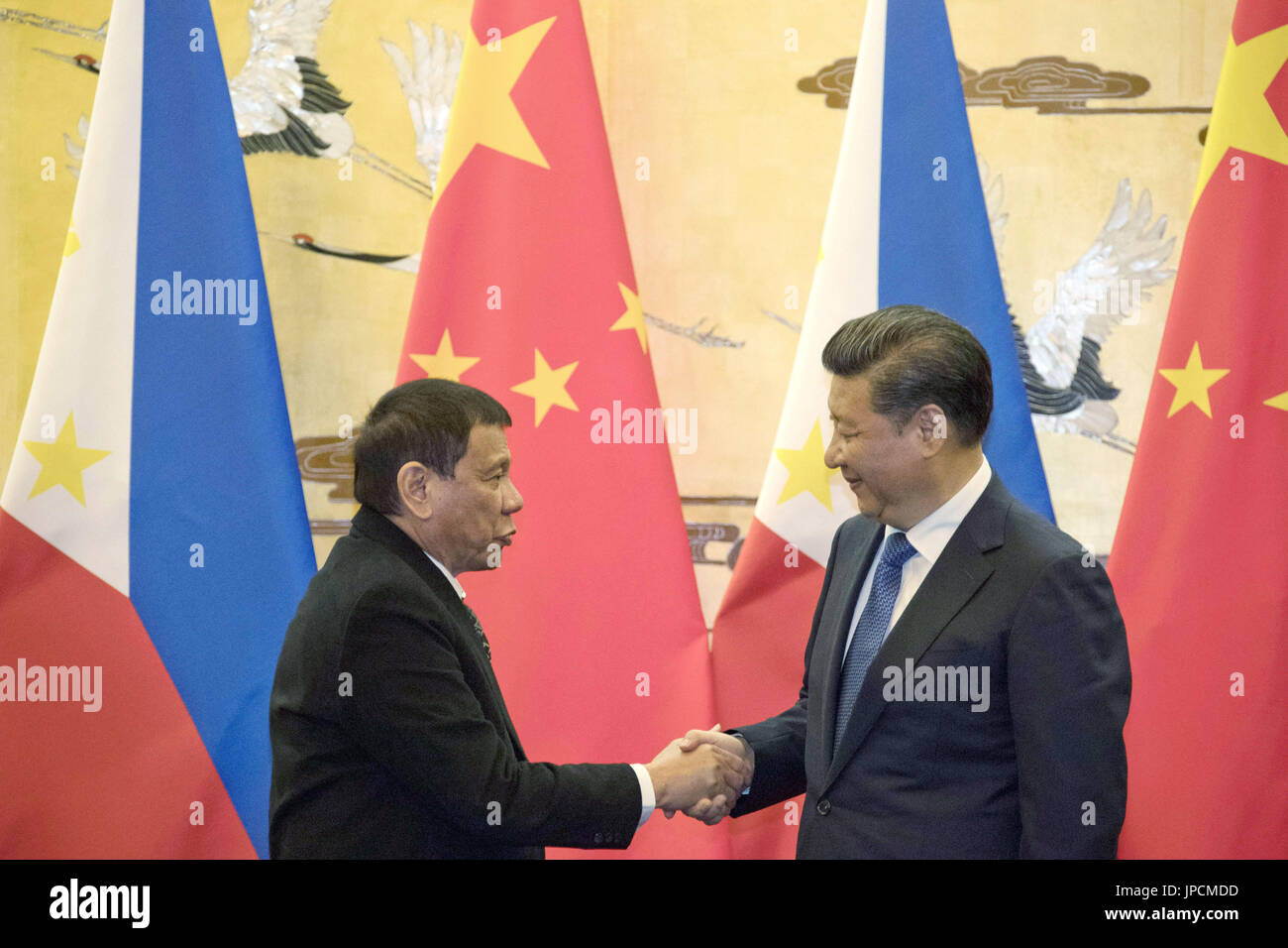 Chinese President Xi Jinping (R) shakes hands with Philippine President ...