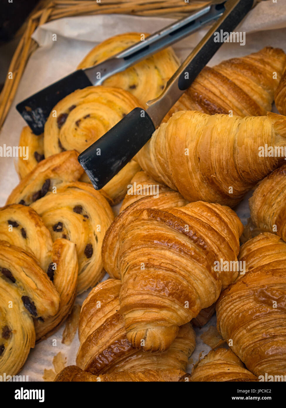 LONDON, UK - JULY 29, 2017: Croissants in a wicker basket tray with ...