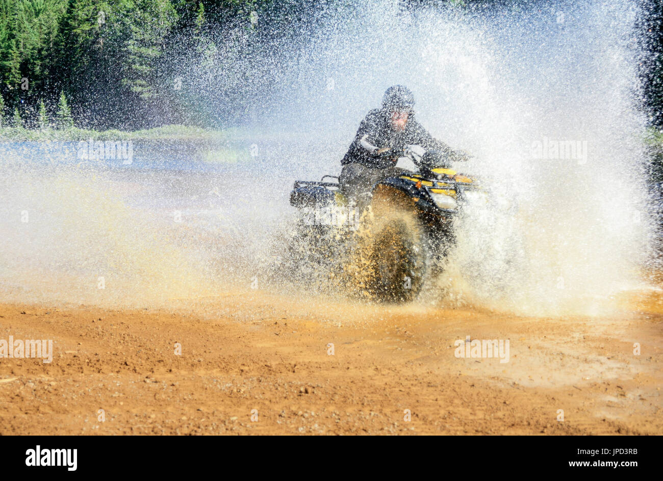 Man driving ATV quad through splashing water with high speed Stock ...