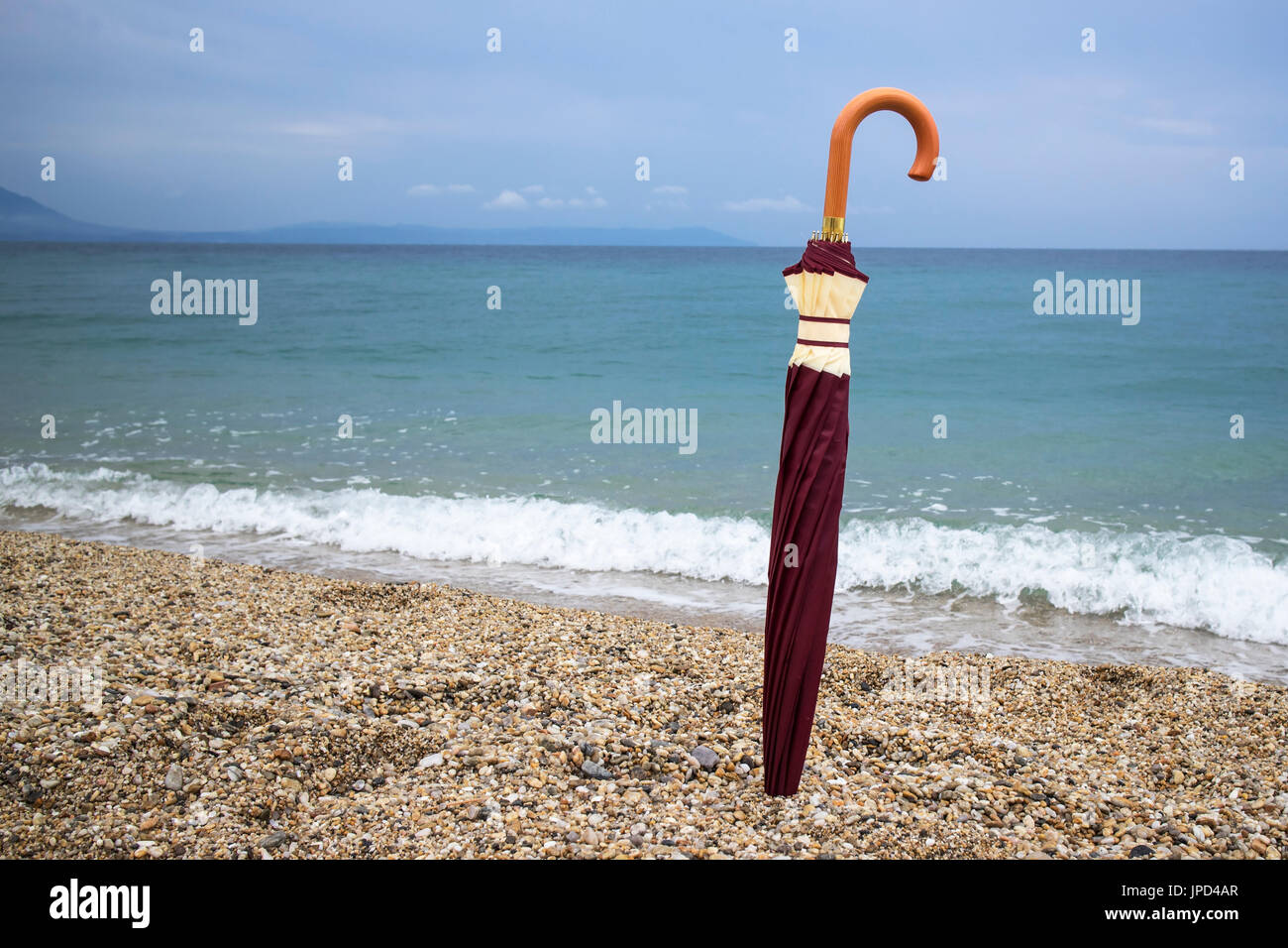 closed umbrella on the beach after a summer storm Stock Photo - Alamy