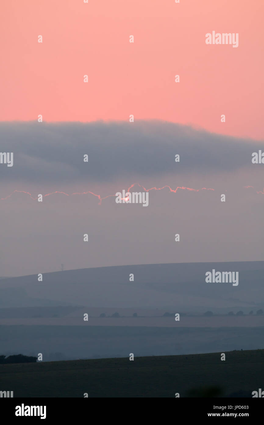 Sun just about to disappear behind cloud at sunset from Seaford, East ...