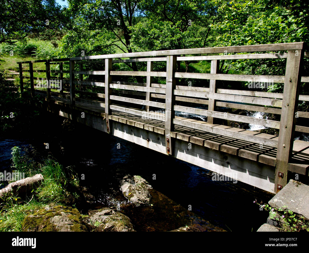 Wooden footbridge over a small river, The Lake District, Cumbria, UK ...