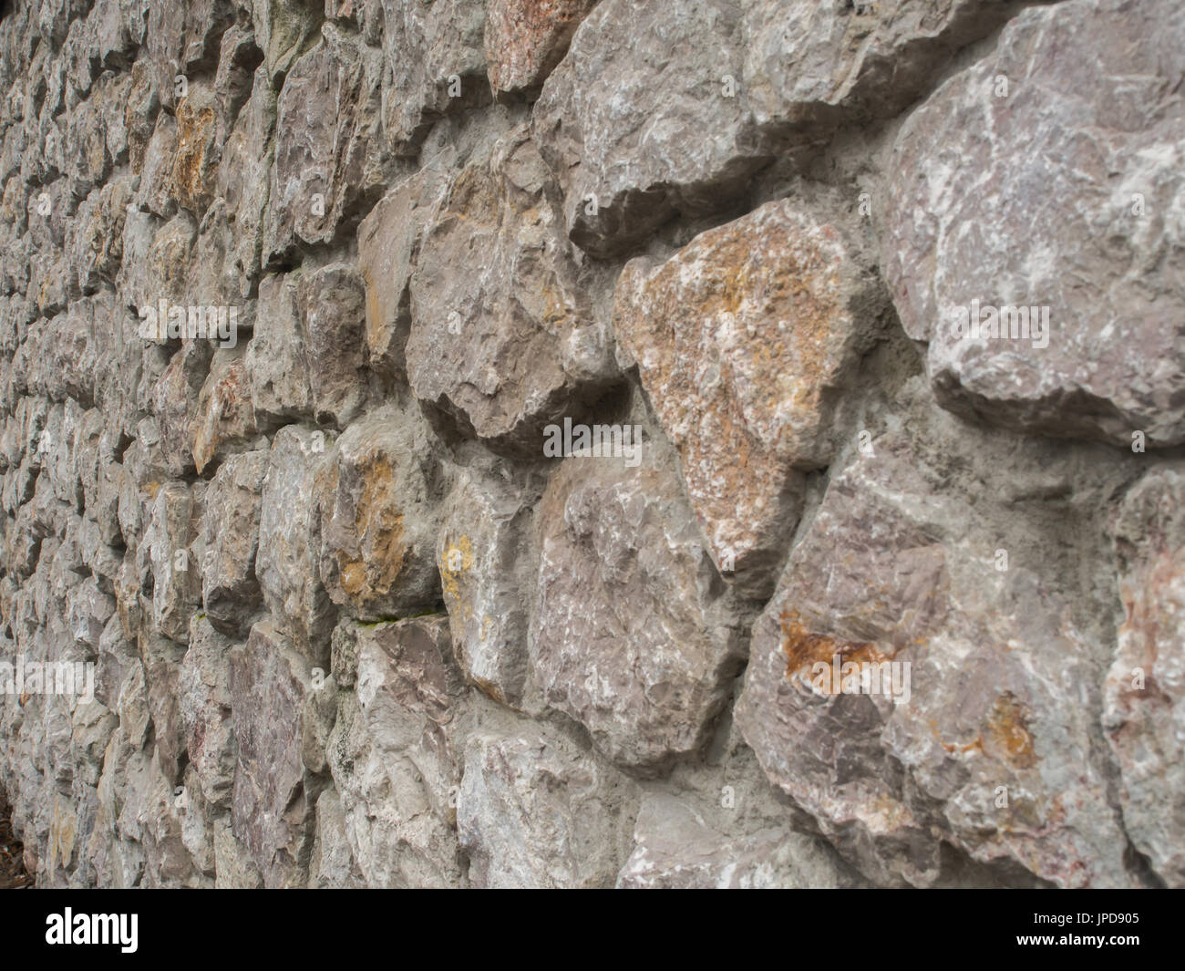 Background. The wall of multi-coloured stones agglomerated with cement ...