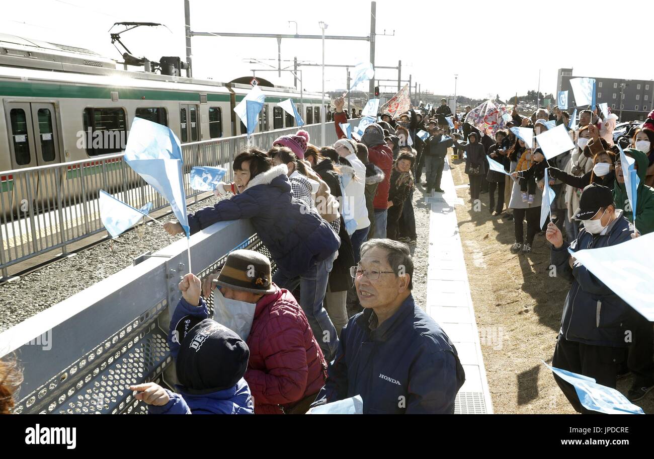 People wave off trains leaving the new Shinchi station in Fukushima ...