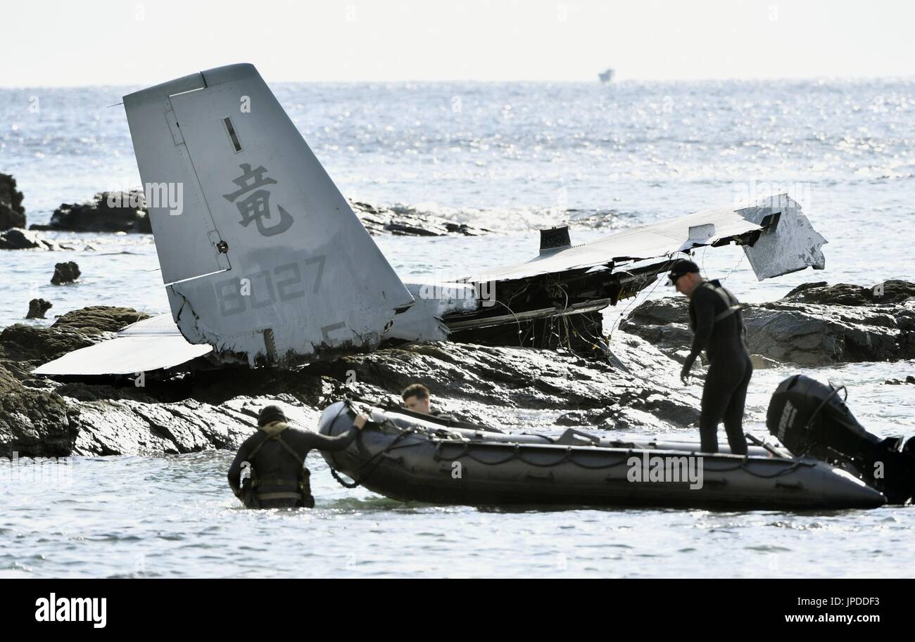 U.S. military personnel examine the site of the crash landing of an MV ...