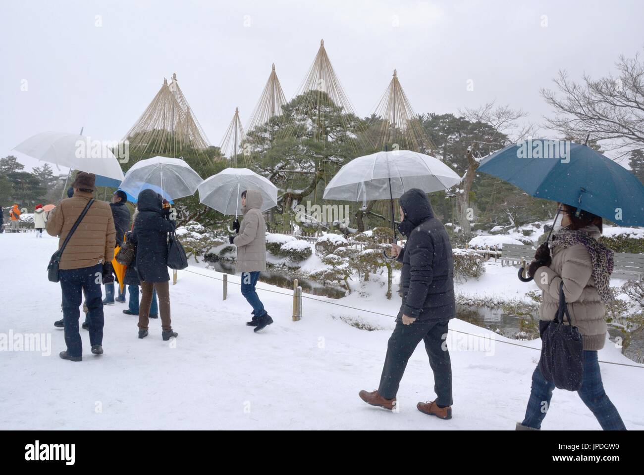 Tourists walk at a snow-covered Kenrokuen in Kanazawa, Ishikawa ...