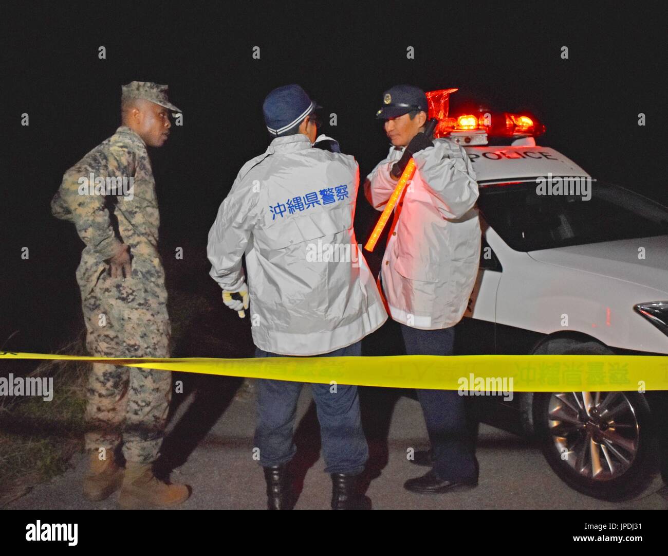 An U.S. military official and Okinawa police officers gather in Uruma ...