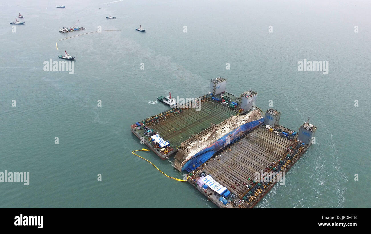 The Sewol ferry lies on its side between two salvage barges off South ...