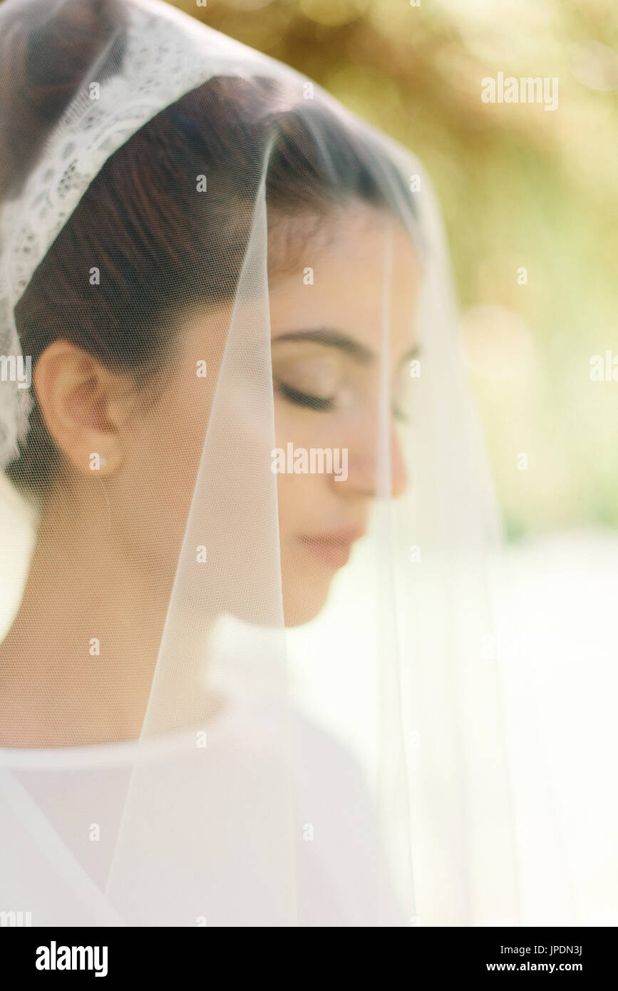 Beautiful bride closes her eyes under white veil Stock Photo - Alamy