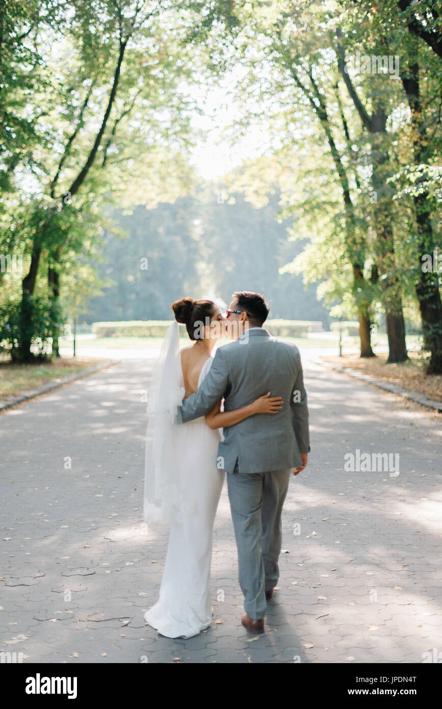 Look from behind at wedding couple kissing in summer park Stock Photo ...