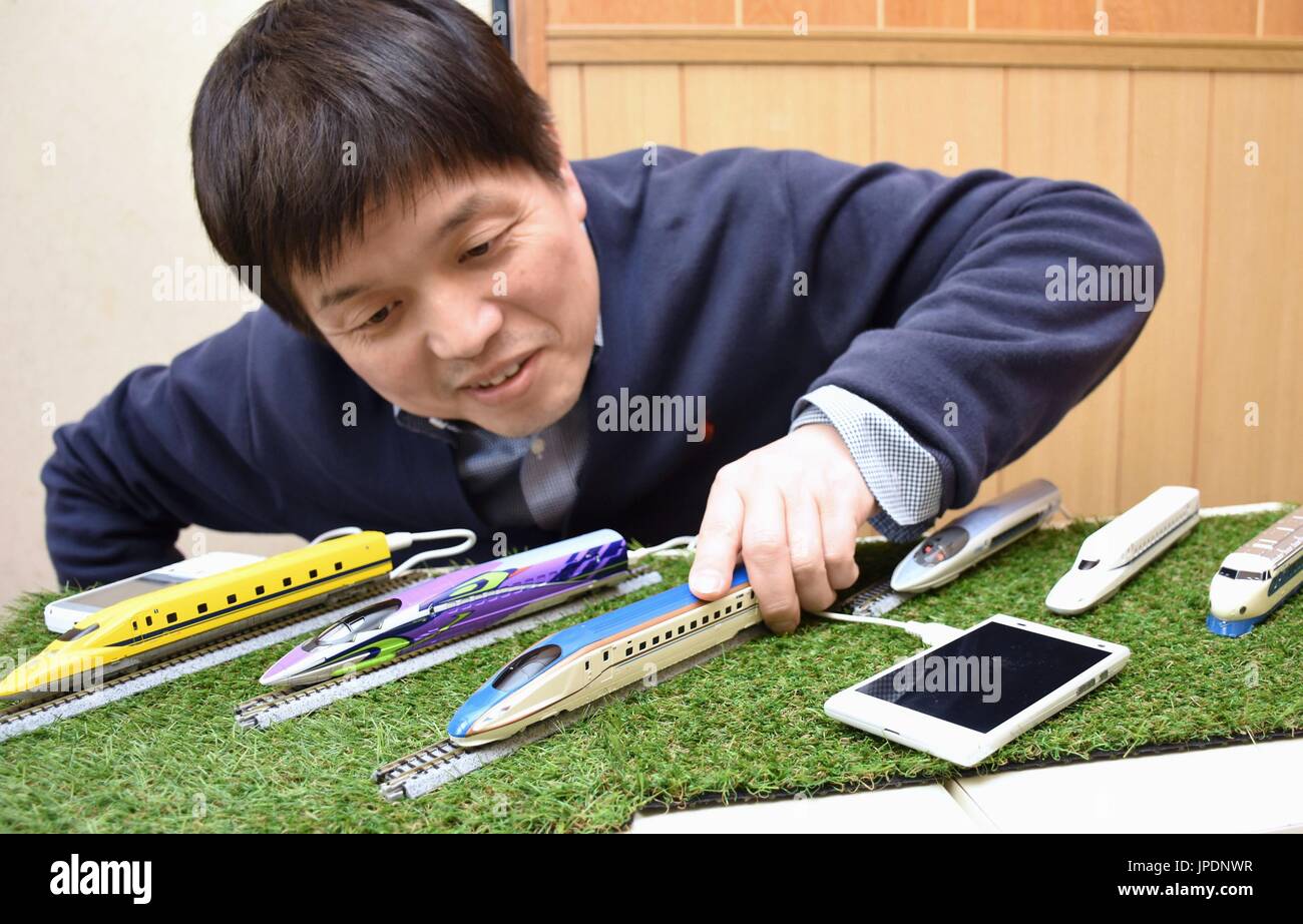 Masaru Yanai, president of Faith Inc., plays with a shinkansen bullet ...