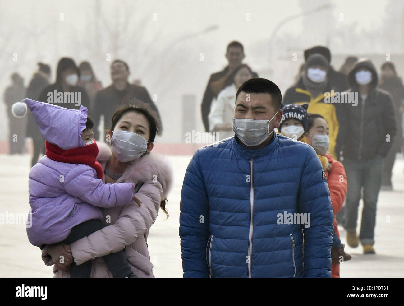 People wear masks to protect themselves against air pollution as they ...