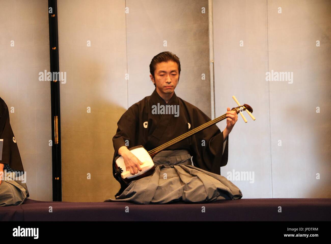 A man plays a shamisen during a performance of the "Nagauta Samon-kai ...