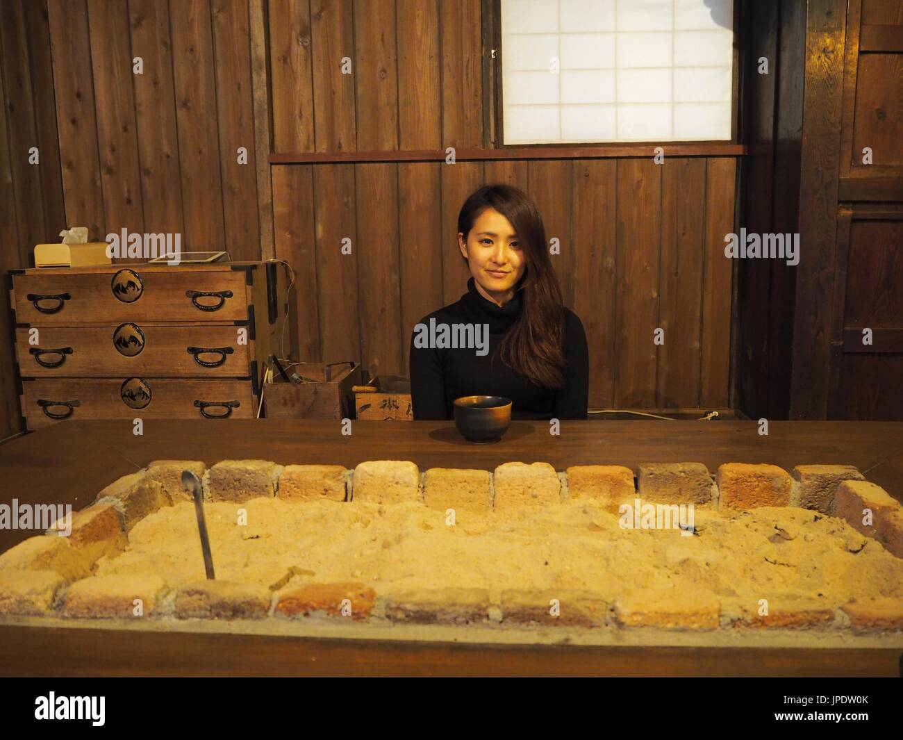 Yoshie Hoyo, owner of Kominka Yado LOOF, poses in front of a hearth at an old traditional-style ...