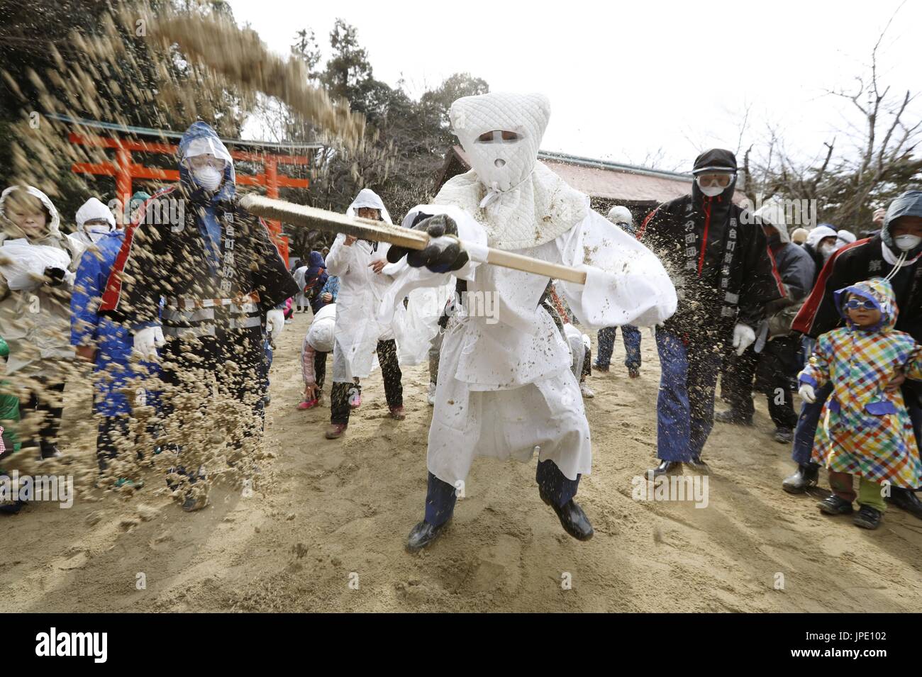 A man disguised as a rice paddy farmer throws sand during the annual ...