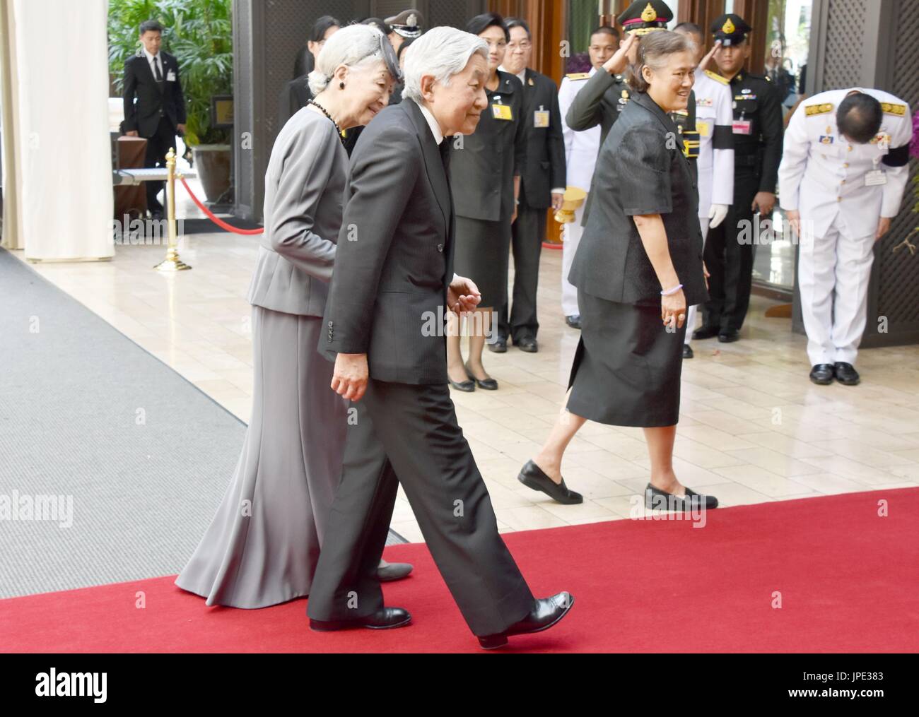 Japanese Emperor Akihito (C) and Empress Michiko enter a Bangkok hotel ...