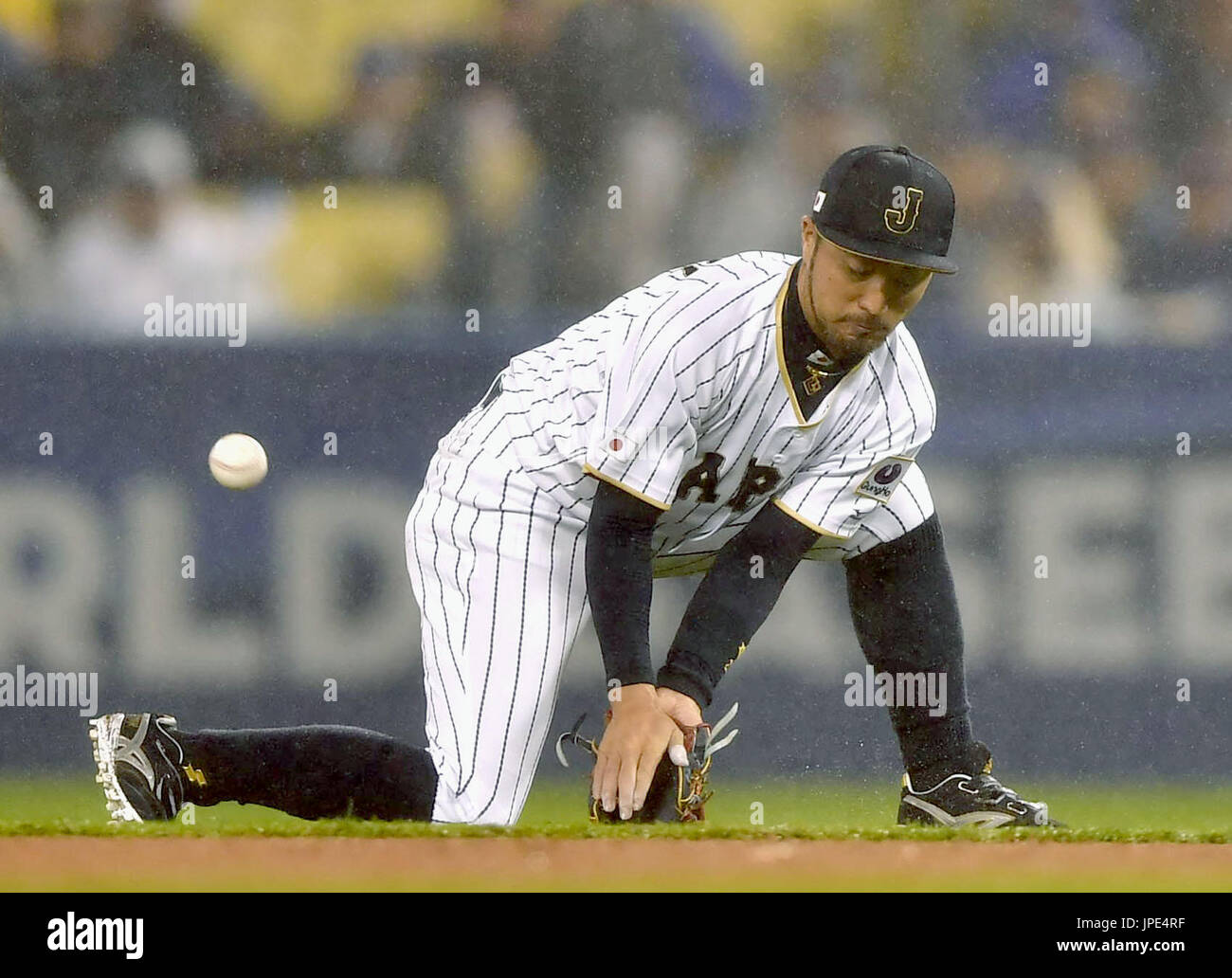 Japanese second baseman Ryosuke Kikuchi commits an error on a ground ...