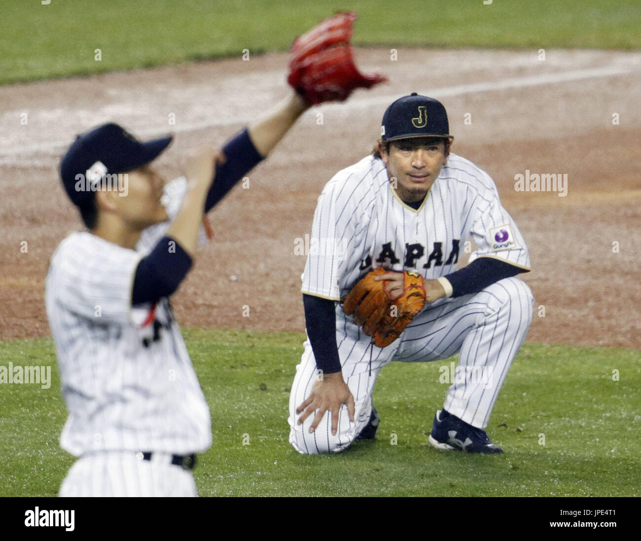 Japanese third baseman Nobuhiro Matsuda (R) reacts after being unable to throw to home plate as ...