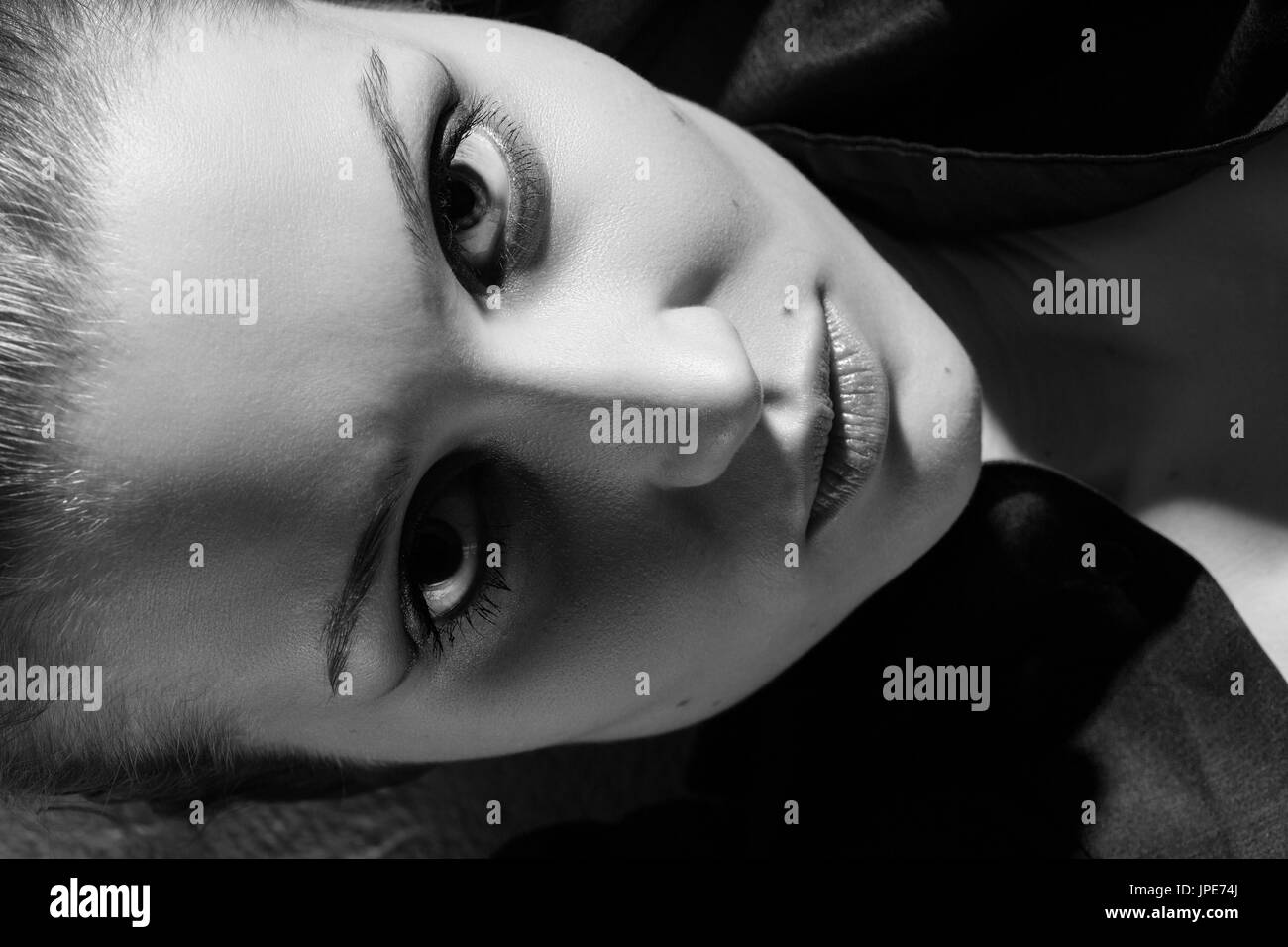 serious luxury woman with natural beauty makeup looks at camera ...