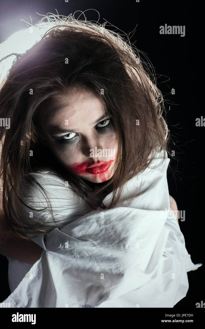 screaming crazy woman with fluffy hair in straitjacket on black ...