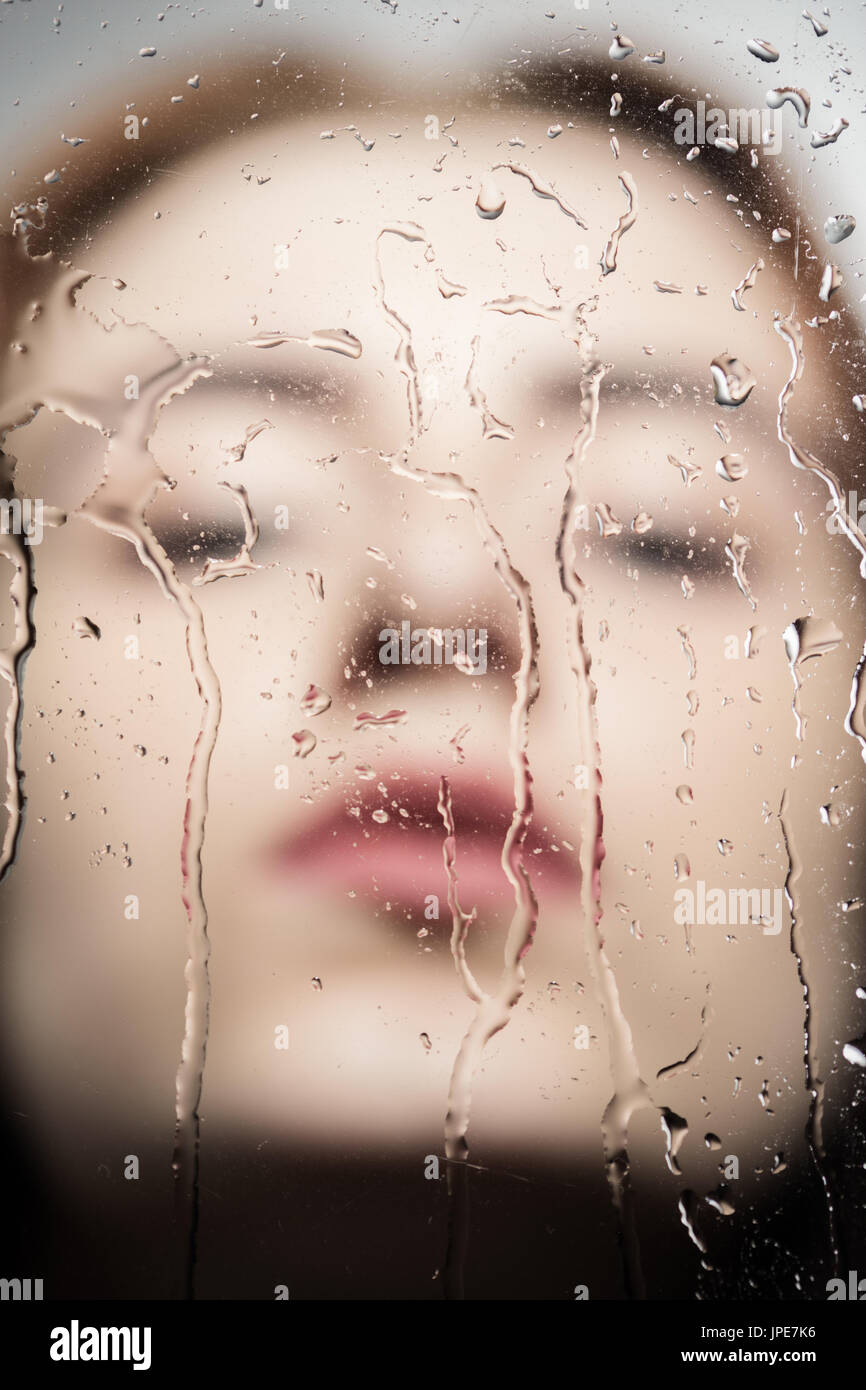 female blurred face closed eyes through glass with water drops Stock ...