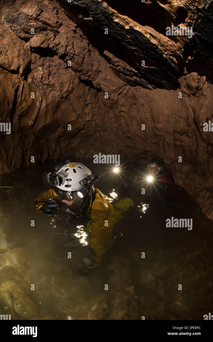 Diving on a cave, Liguria, Italy, Europe. A woman speleologist filming ...