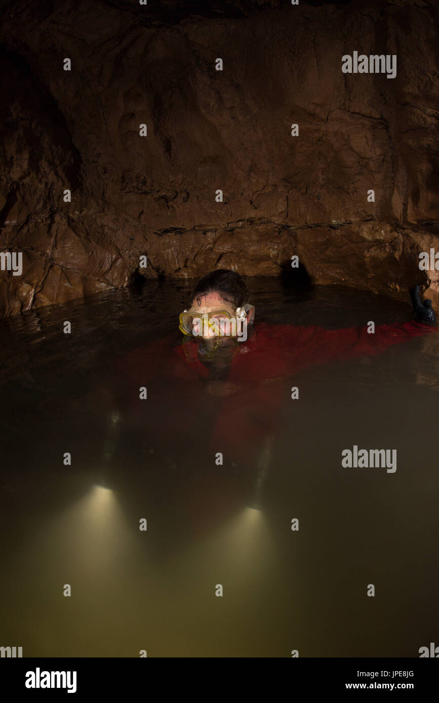 Diving on a cave, Liguria, Italy, Europe. A woman speleologist filming ...