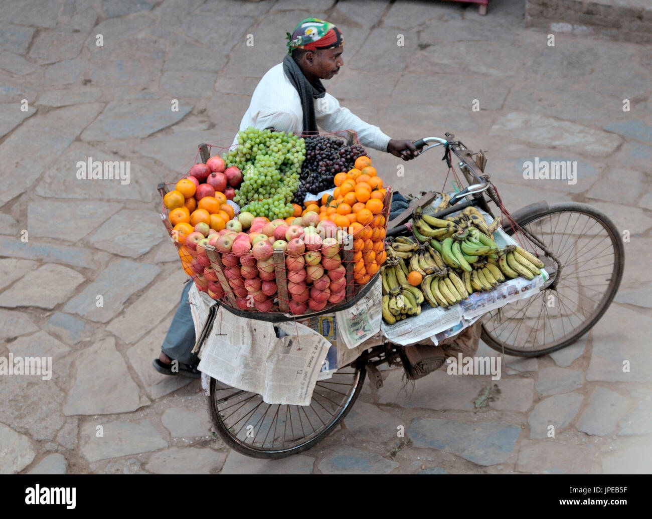 Bhaktapur, Nepal. A fruits vendor, walk with his bike in the old street ...