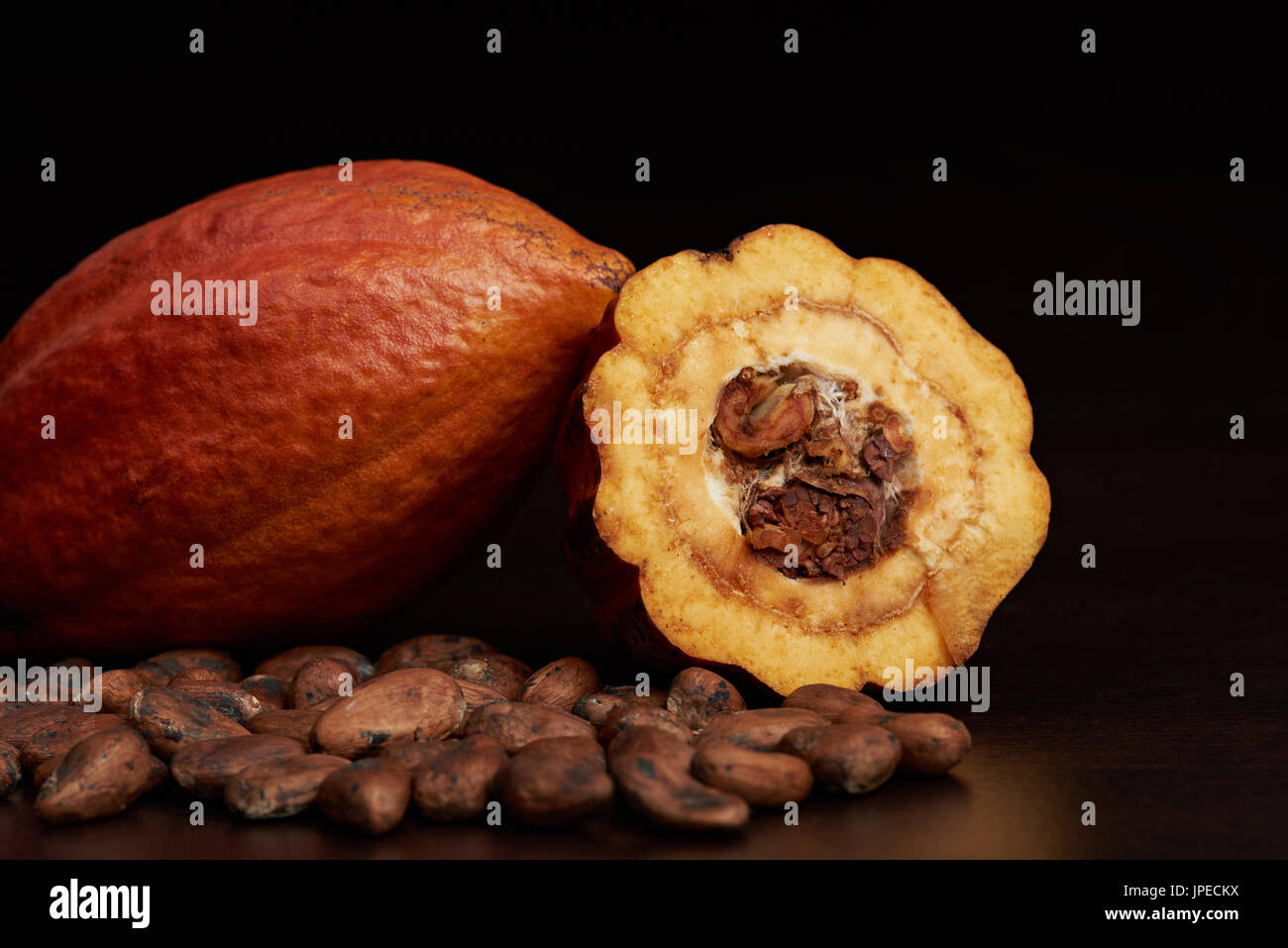 Raw cacao pod close up laying on dark wood background Stock Photo - Alamy