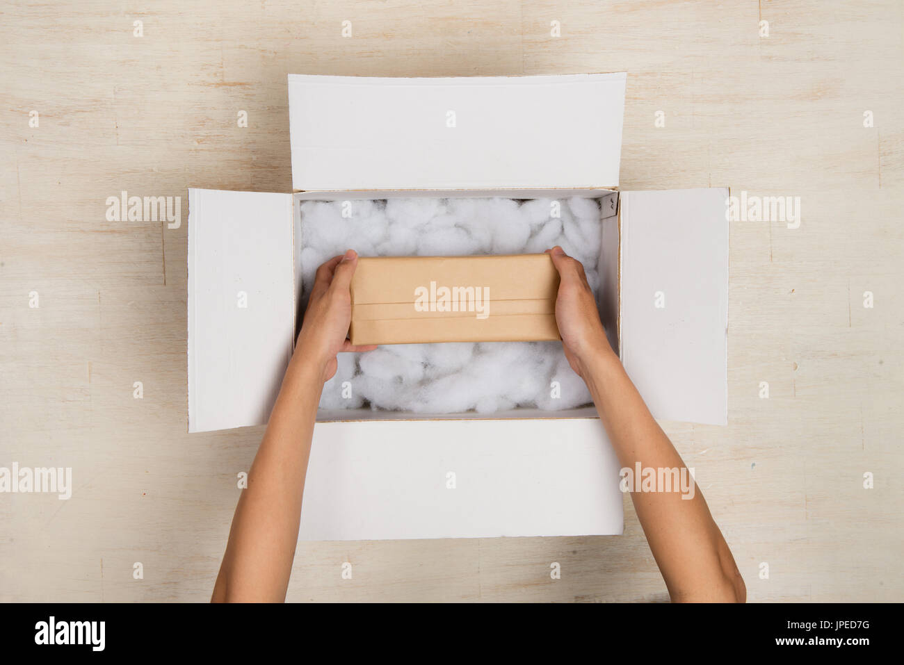 Opening a carton box. Hands holding gift box in cardboard box Stock ...