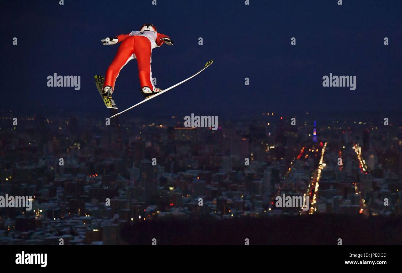 Japanese ski jumper Naoki Nakamura leaps toward the night view of ...