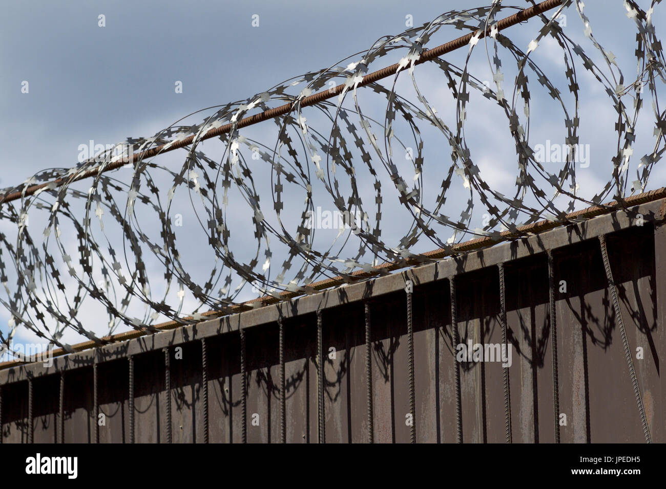 Barbed wire wound to the top of a fence, Russia Stock Photo - Alamy