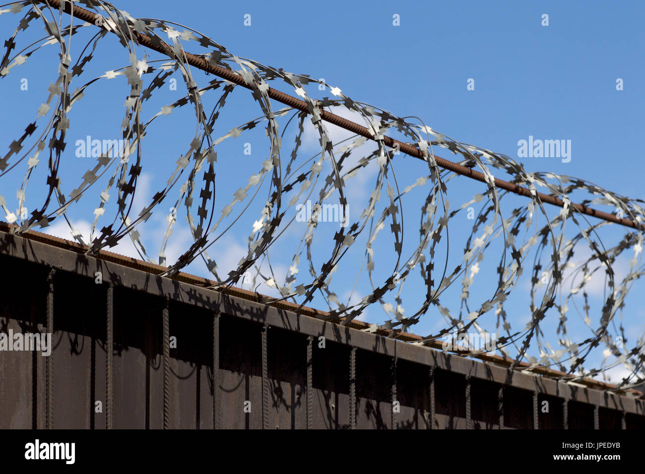 Barbed wire wound to the top of a fence, Russia Stock Photo - Alamy