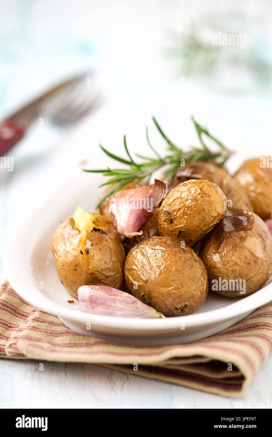 Oven baked potatoes or jacket potatoes with baked garlic cloves and ...