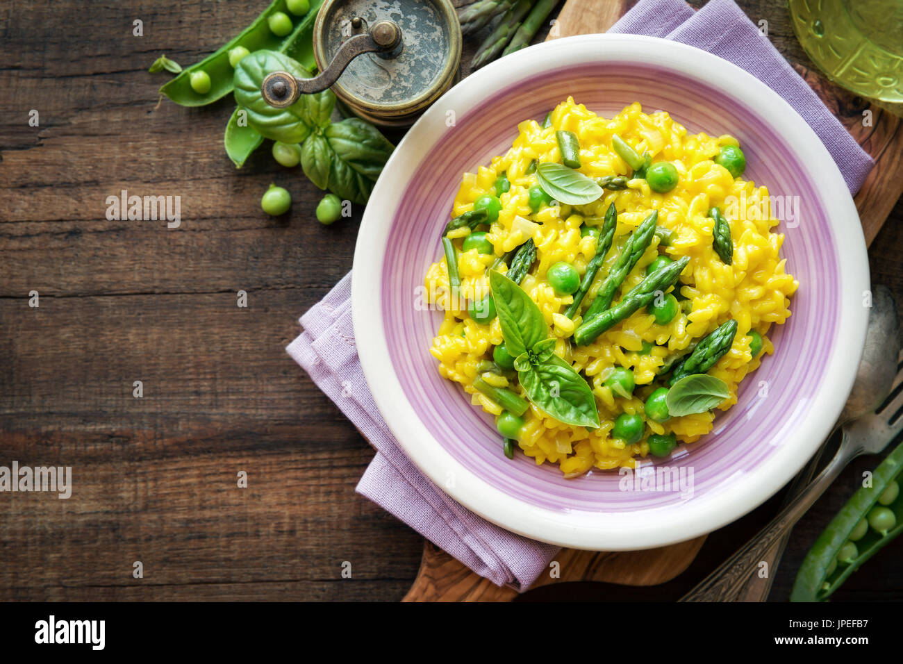 Italian saffron risotto with green peas and asparagus. Overhead view ...