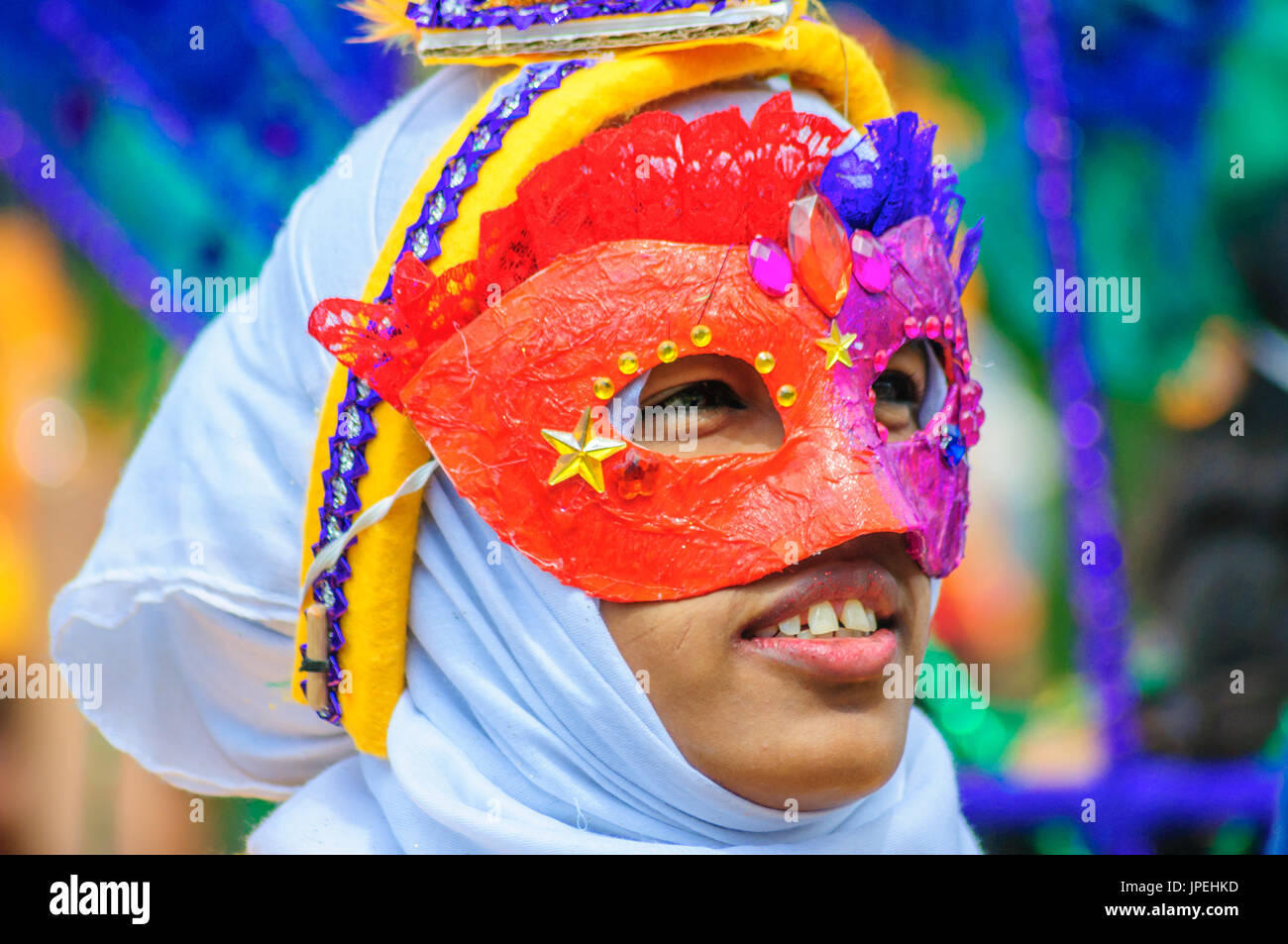 Female performer wearing a colorful costume and mask in the parade on ...