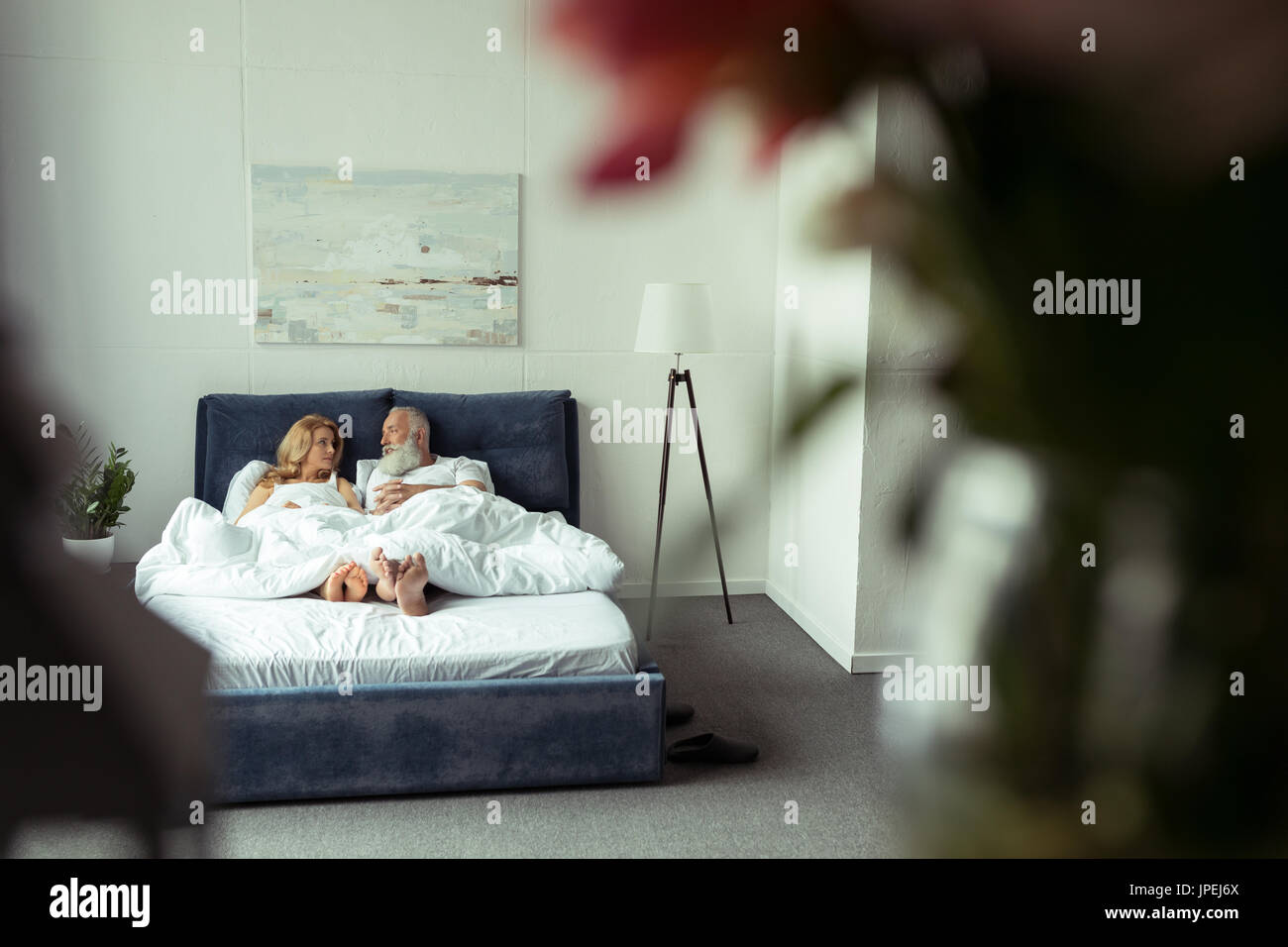 Beautiful Happy Mature Couple Lying Together In Bed And Smiling Each