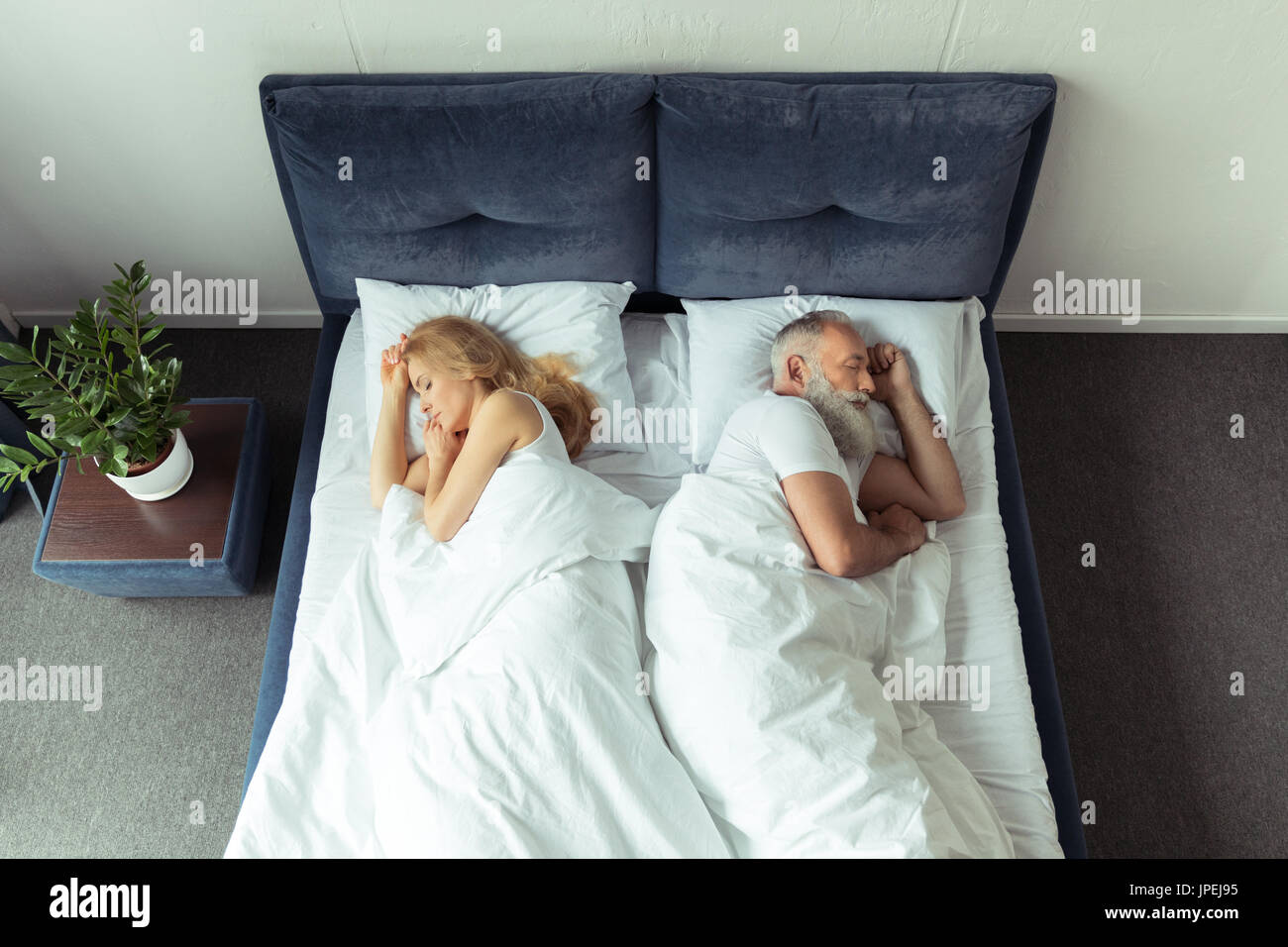 top view of couple sleeping back to back in bed Stock Photo - Alamy