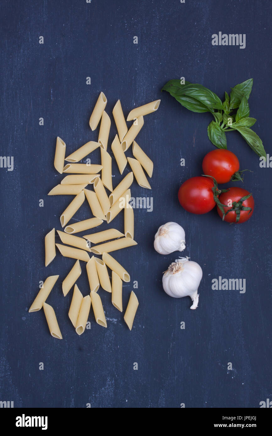 raw penne pasta with tomato, basil and garlic Stock Photo - Alamy