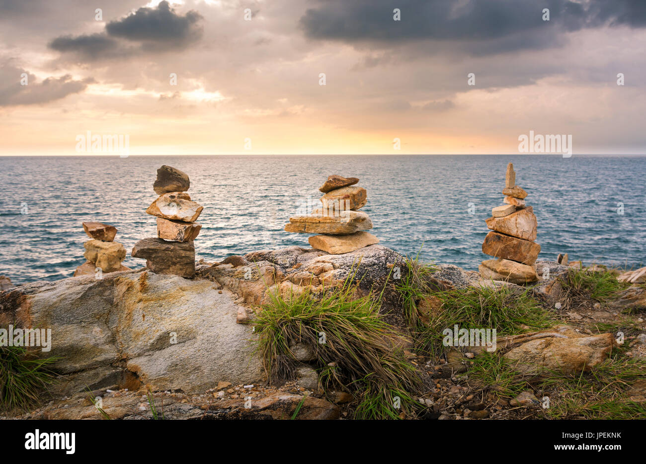 Stacked stones on a beach in Thailand at sunset Stock Photo - Alamy