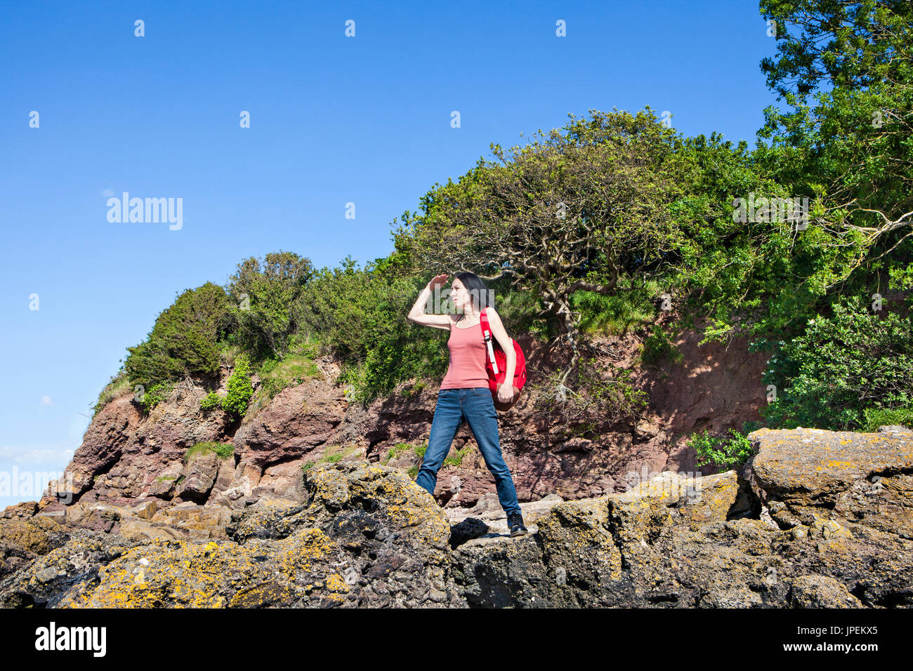 Woman standing at rocks hi-res stock photography and images - Alamy