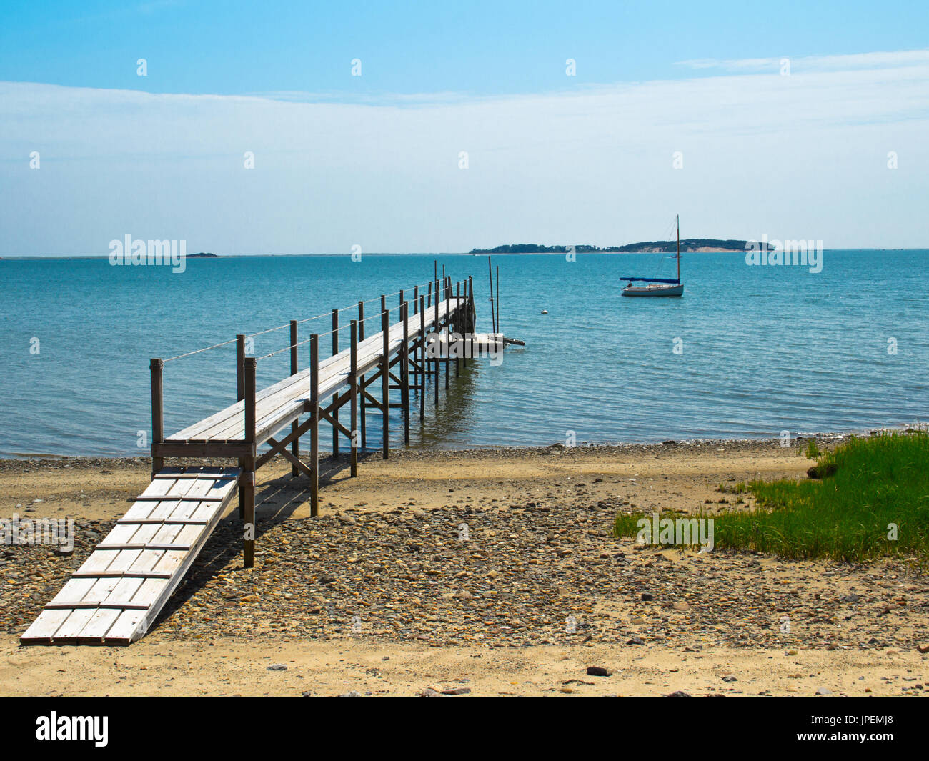 A pier juts out from Pleasant Bay beach near Chatham, MA, on Cape Cod ...