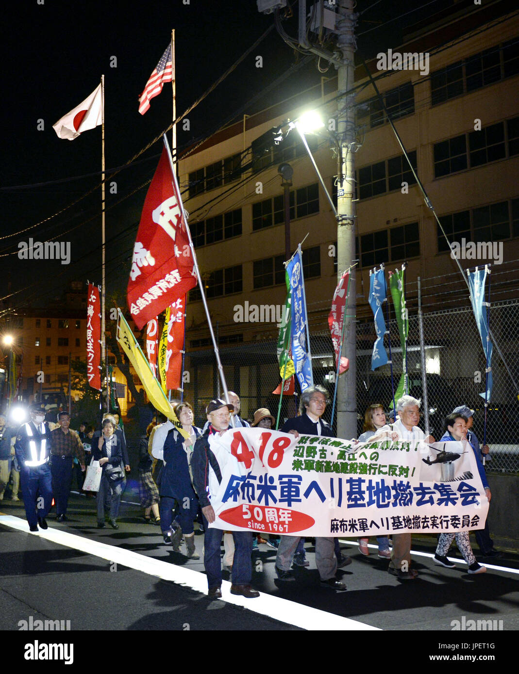 People march around Akasaka Press Center, a U.S. Army facility in the ...