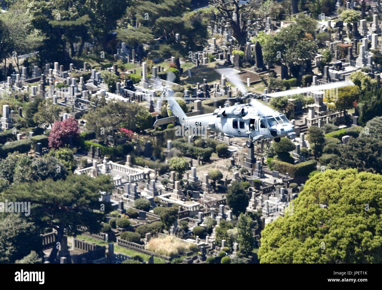 A U.S. military helicopter flies low over Aoyama Cemetery in central ...
