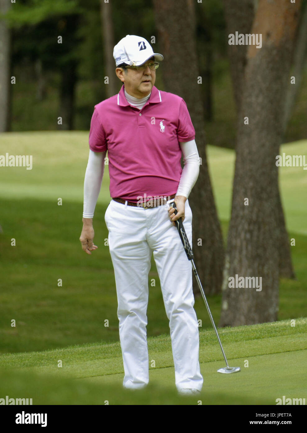 Prime Minister Shinzo Abe walks across a green at a golf course near ...