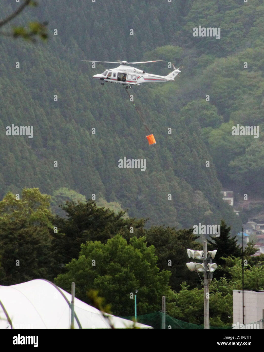 A helicopter works to extinguish a forest fire in Kamaishi ...