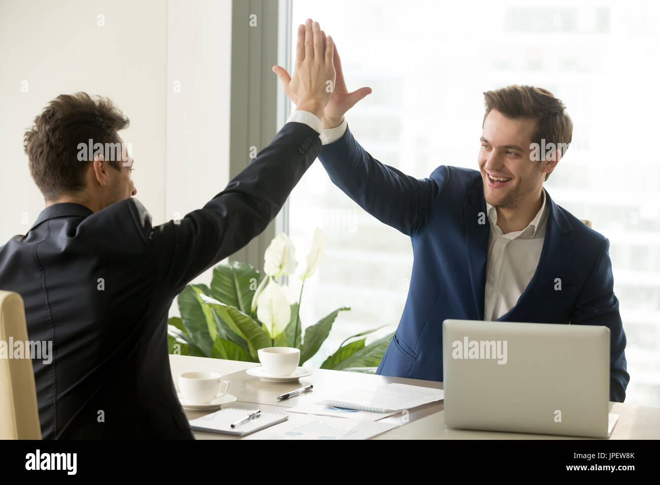 Businessman giving high five to partner, business achievement, t Stock ...